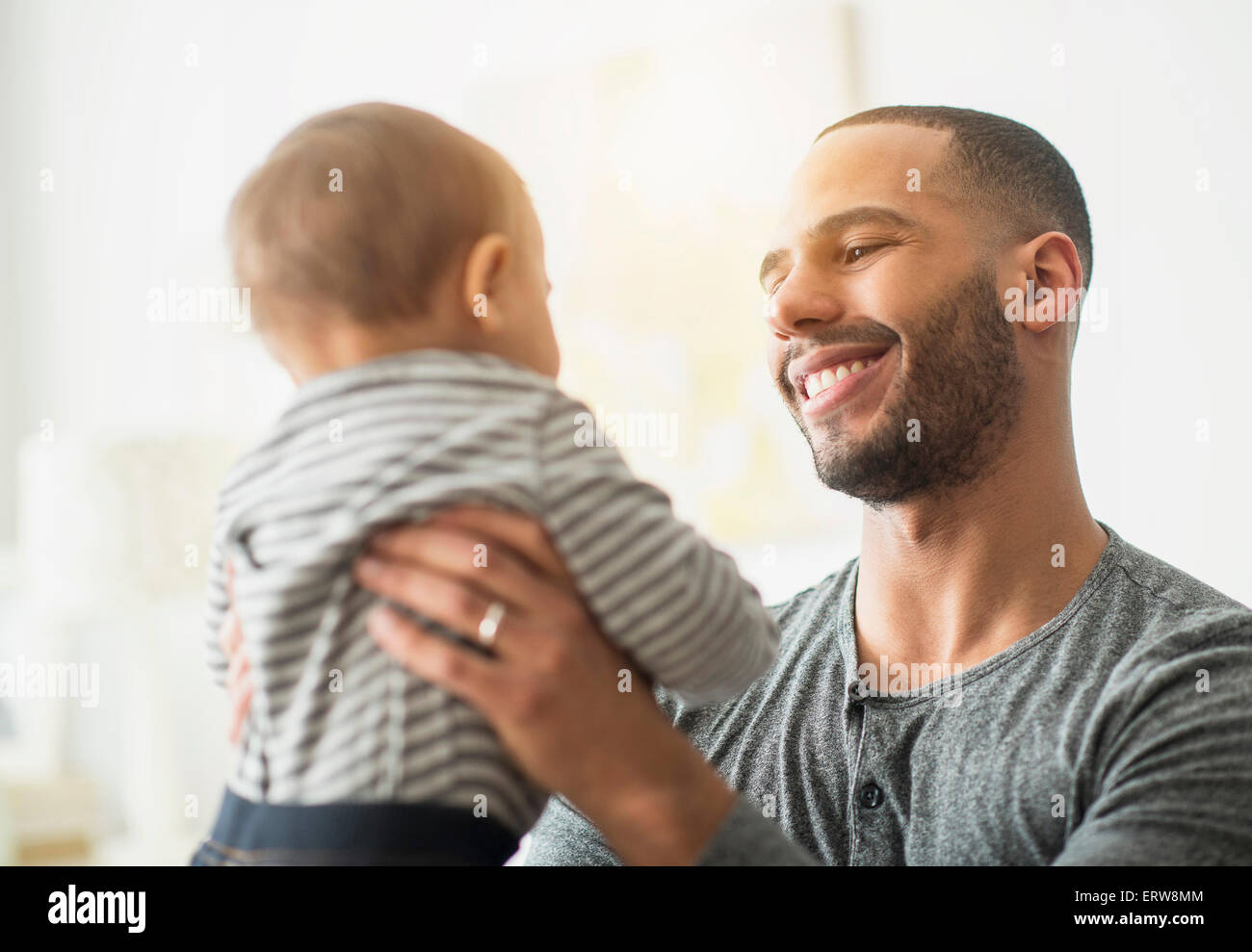 Smiling father holding baby son Stock Photo - Alamy