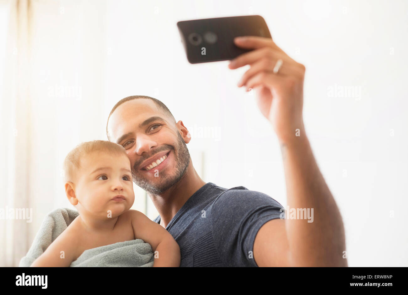 Father taking cell phone photograph with baby son Stock Photo - Alamy