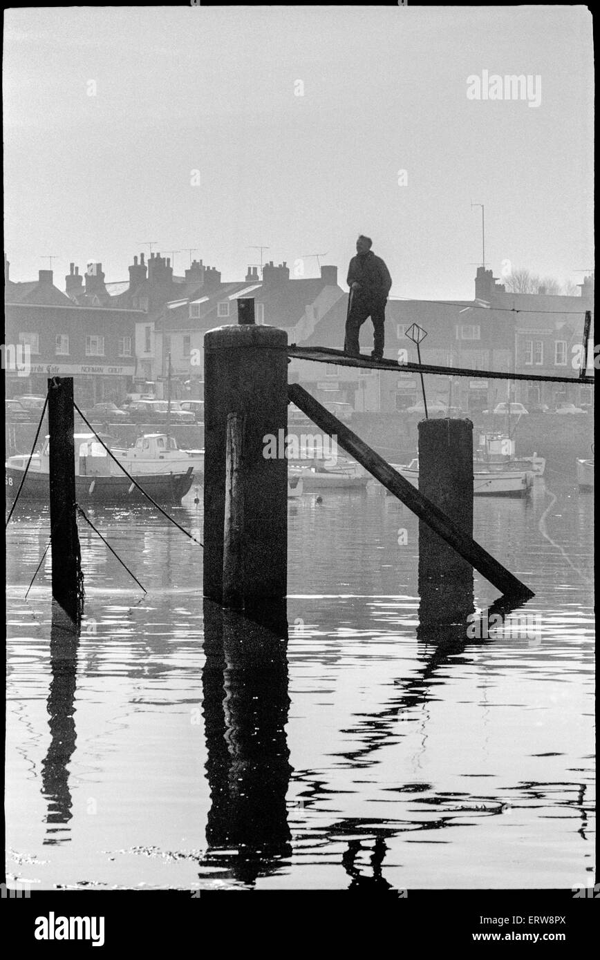 Man standing on a mooring gangplank. St. Peter port harbour, Guernsey ...