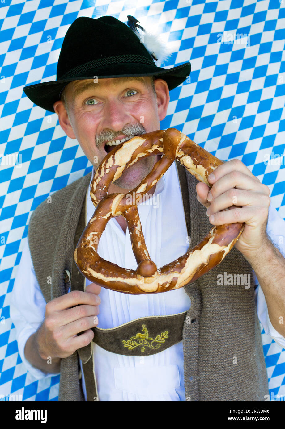 portrait of a bavarian man eating a giant pretzel Stock Photo - Alamy