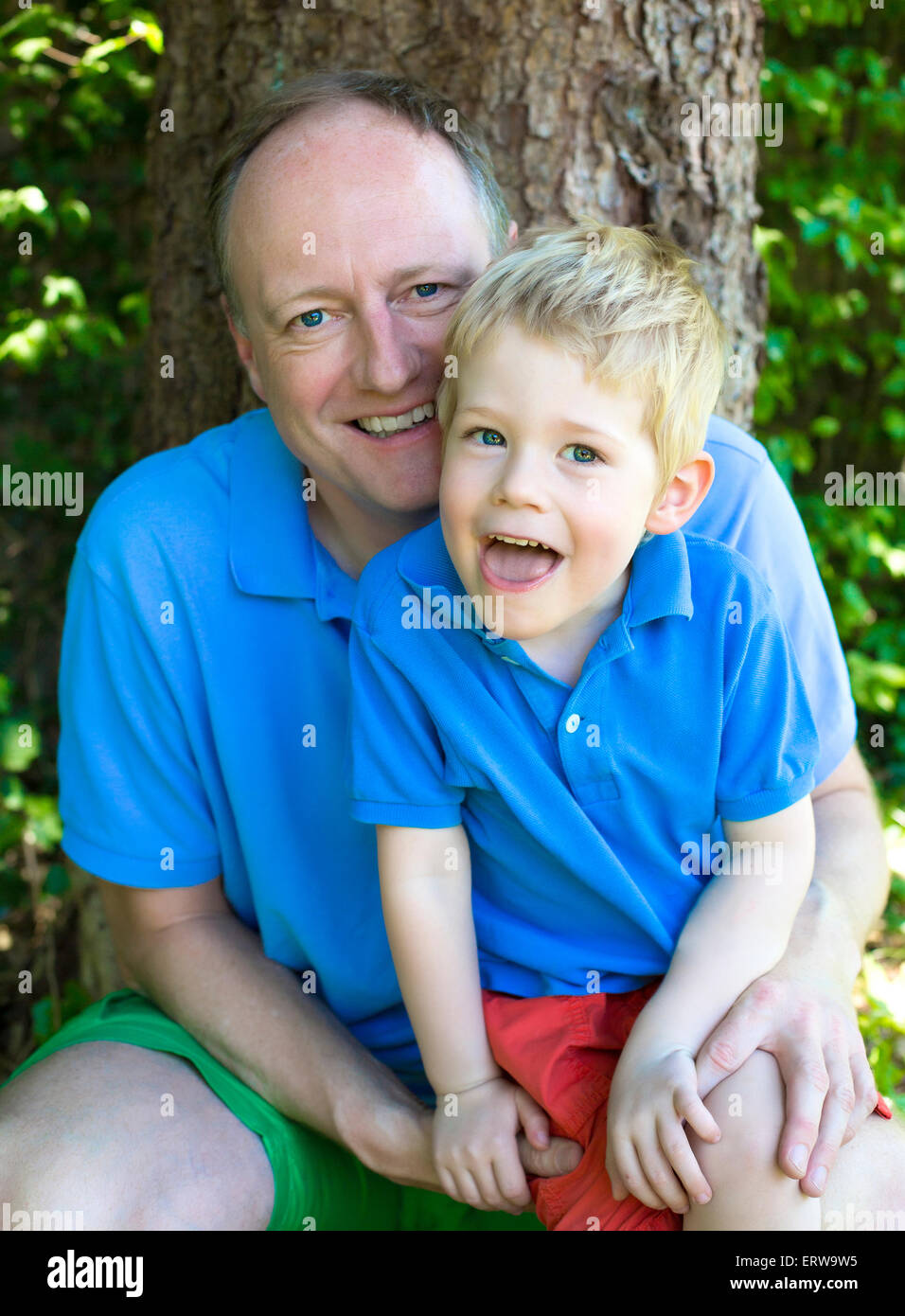 portrait of a father and his son in front of a tree Stock Photo - Alamy