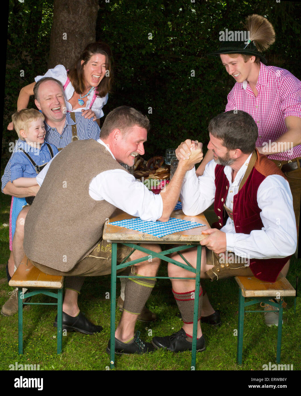 two bavarian men pressing hands while people watching Stock Photo - Alamy