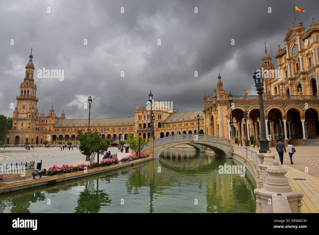 Couple walking under dark clouds at the Main Building of Plaza de ...