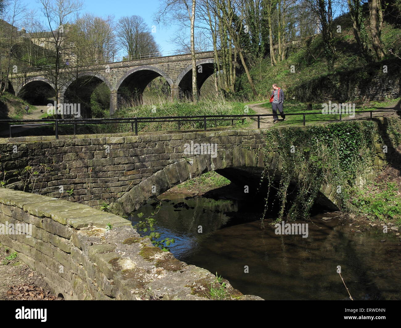 Man walking over a stone footbridge in New Mills Stock Photo - Alamy