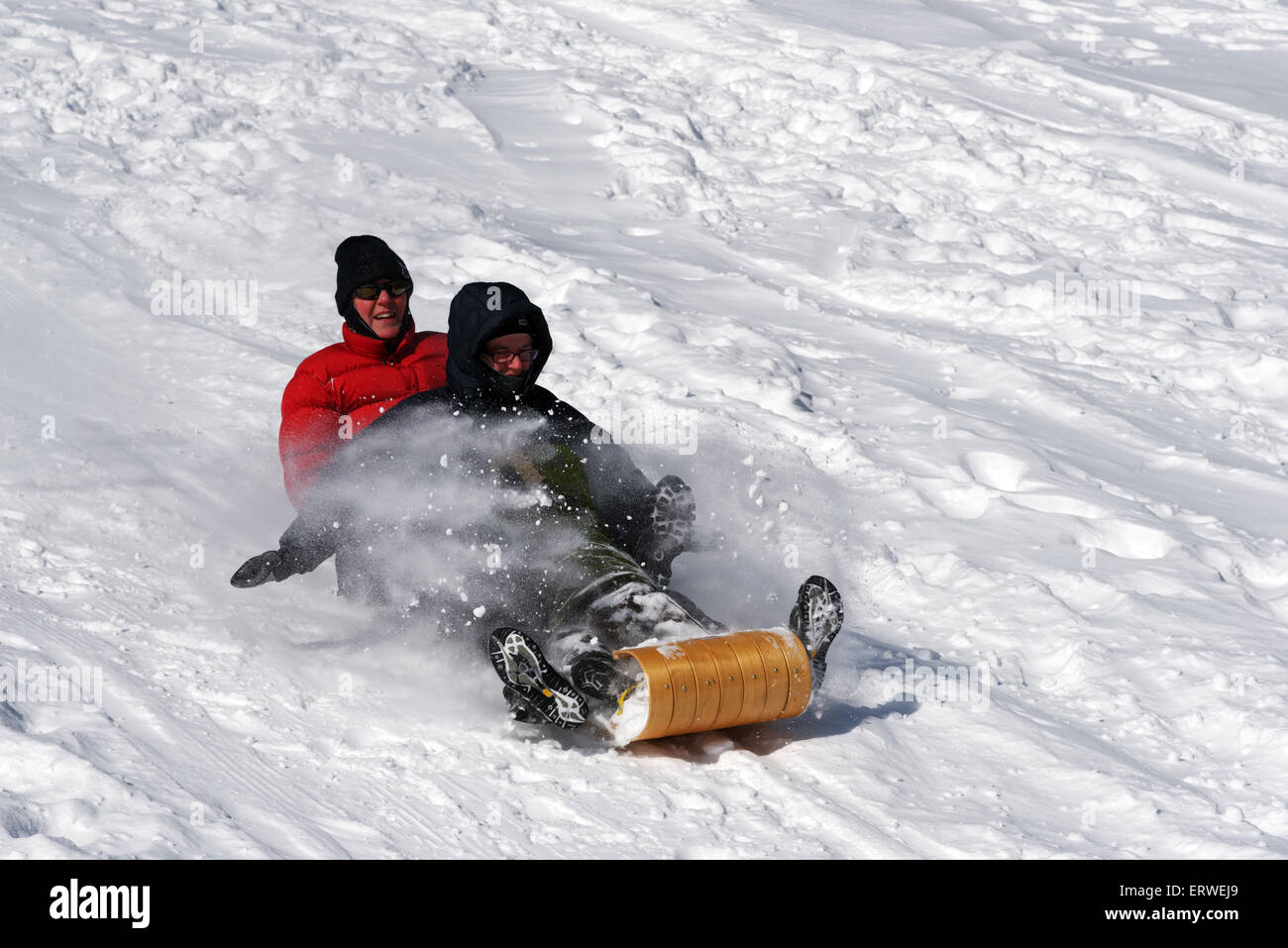Two women laughing on a sledge Stock Photo - Alamy