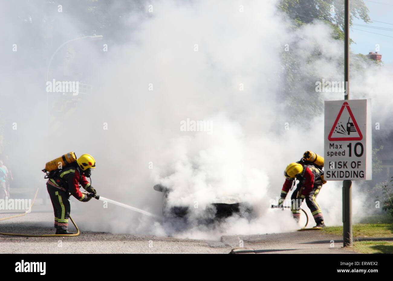 Firefighters tackle a vehicle fire on a residential street in ...