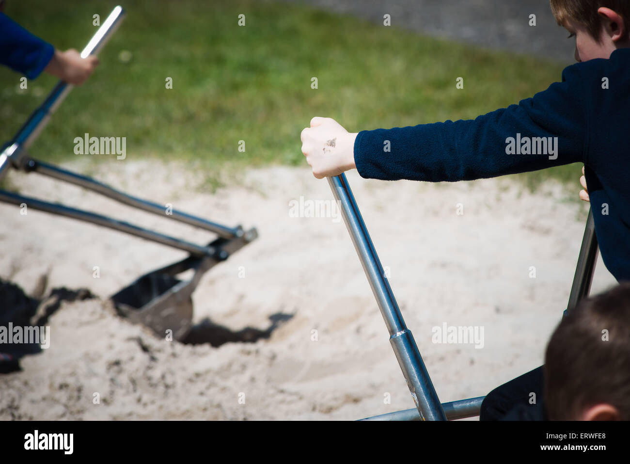 Kid playing with metal digger at kids play area in sand Stock Photo - Alamy