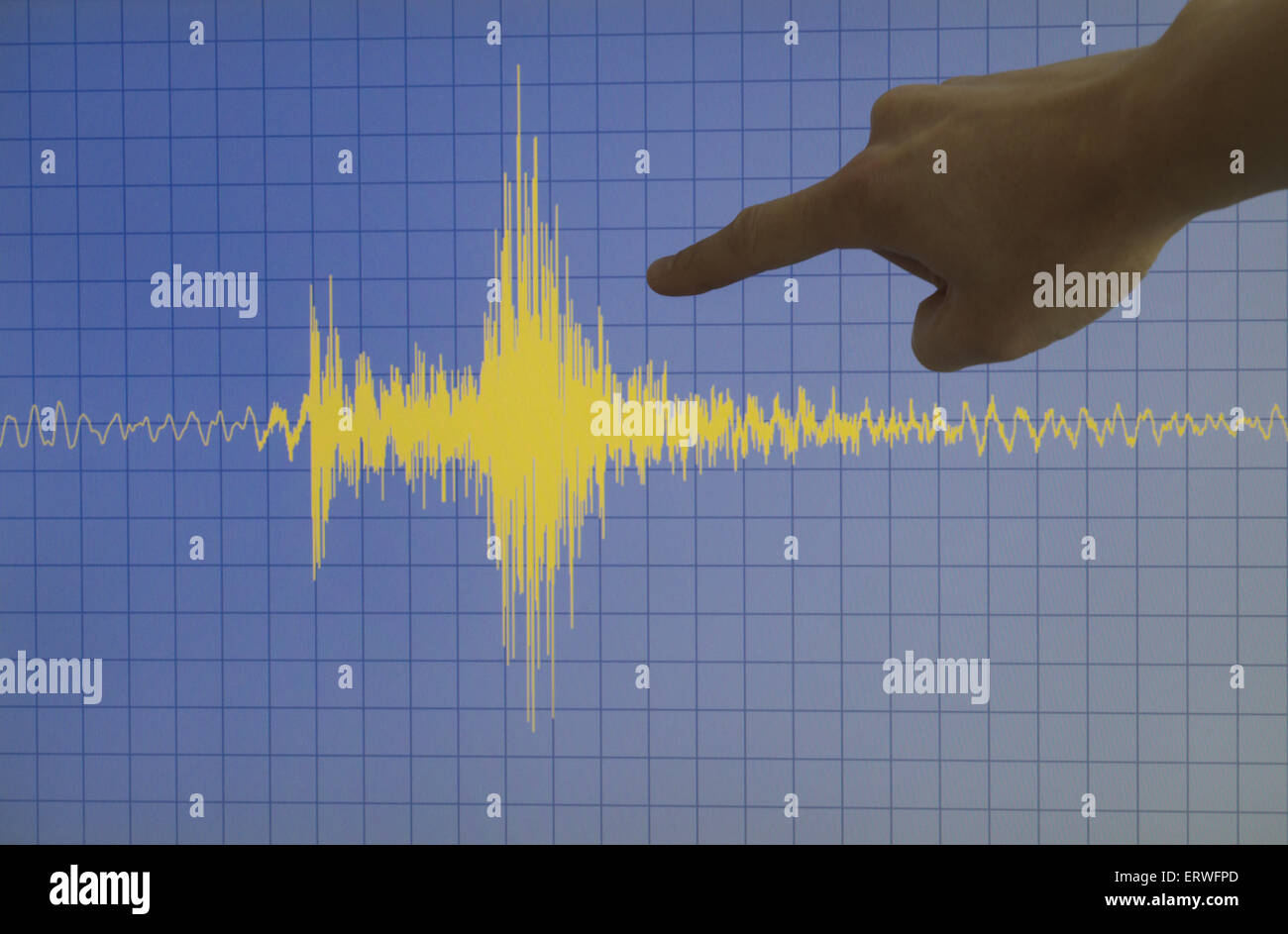 Hand pointing a yellow earthquake with a blue background and a grid ...