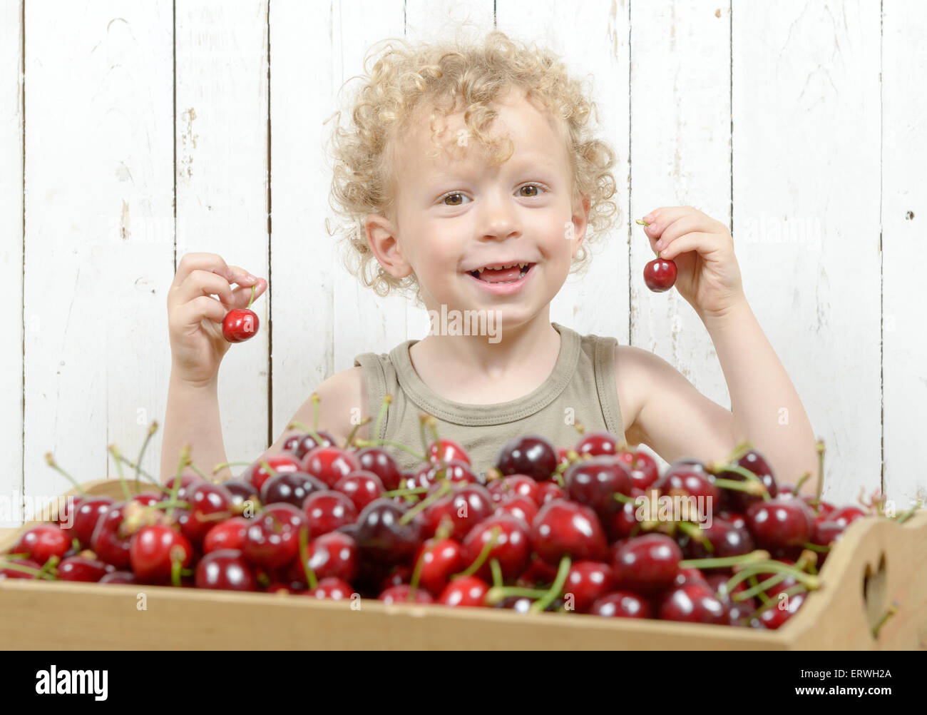a small blond boy playing with cherries Stock Photo - Alamy
