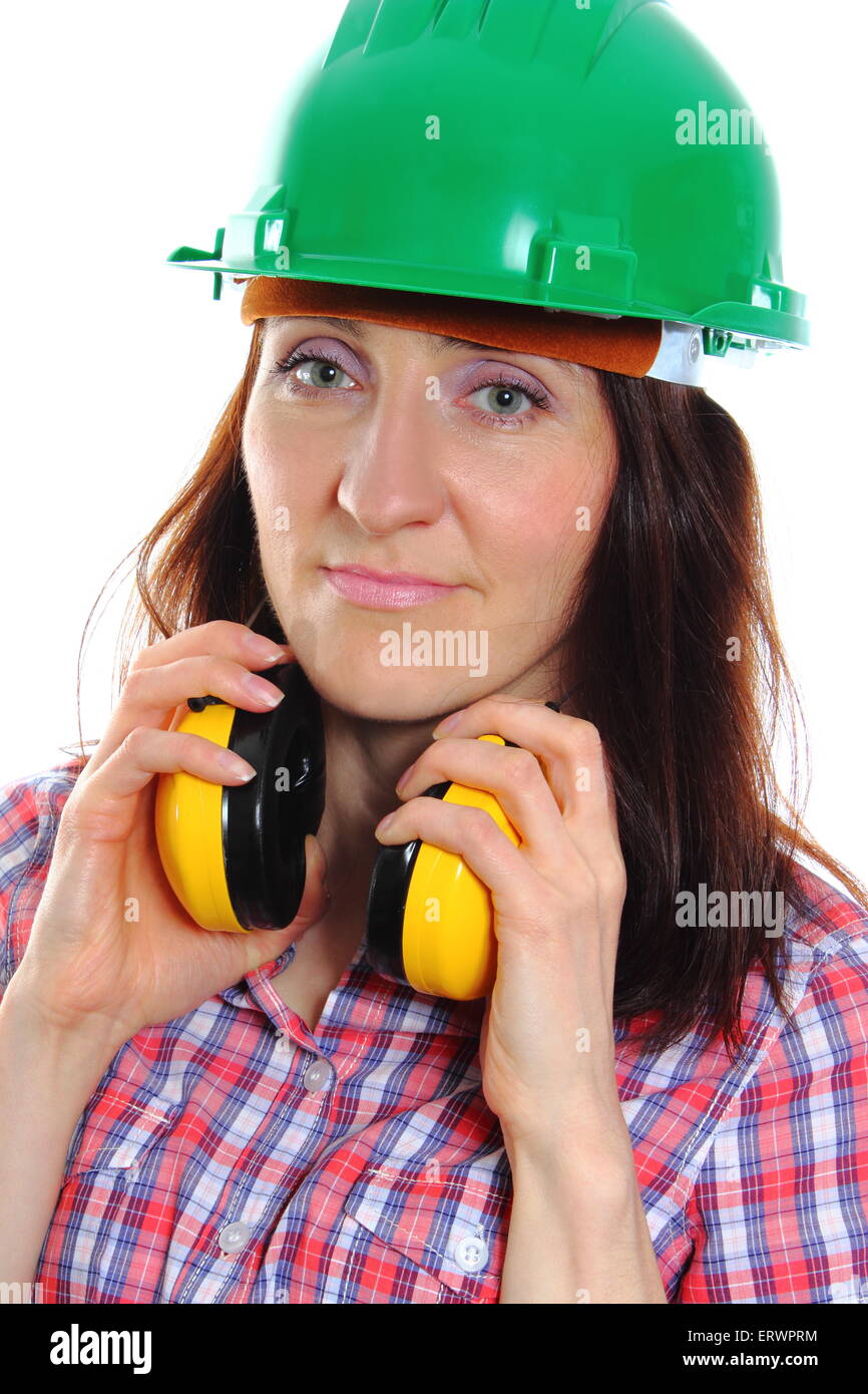 Female construction worker wearing green helmet and protective headphones, safety at work and ...