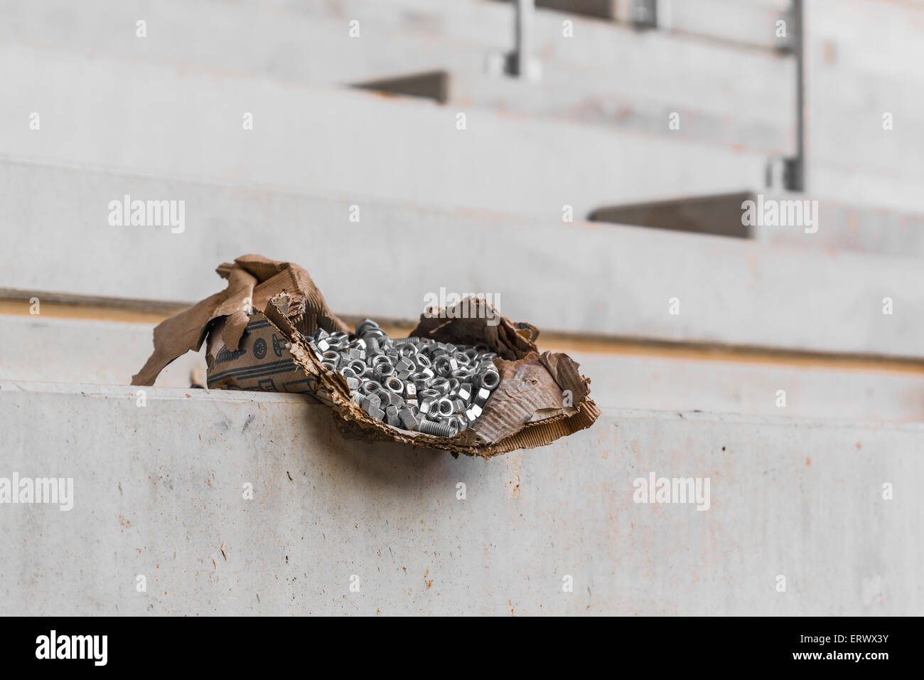 torn paper box with metal screws and nuts Stock Photo - Alamy