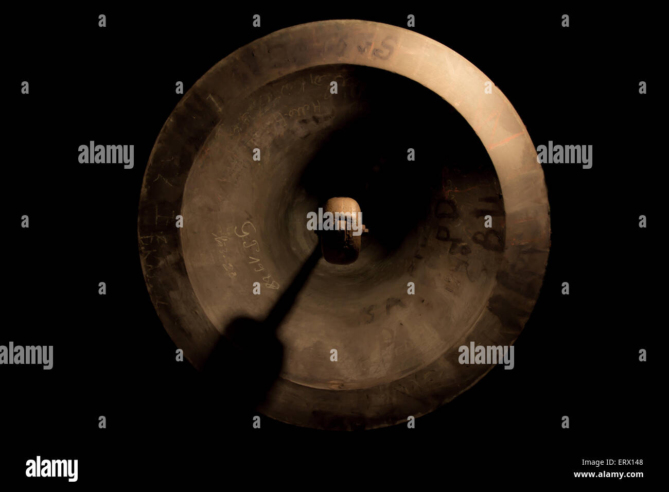 A church bell, shot taken from below, the clapper has a defined shadow ...