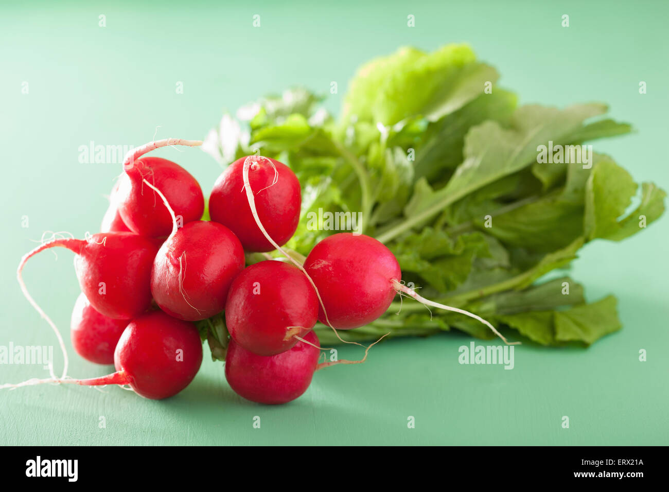 fresh radish with leaves over green background Stock Photo - Alamy