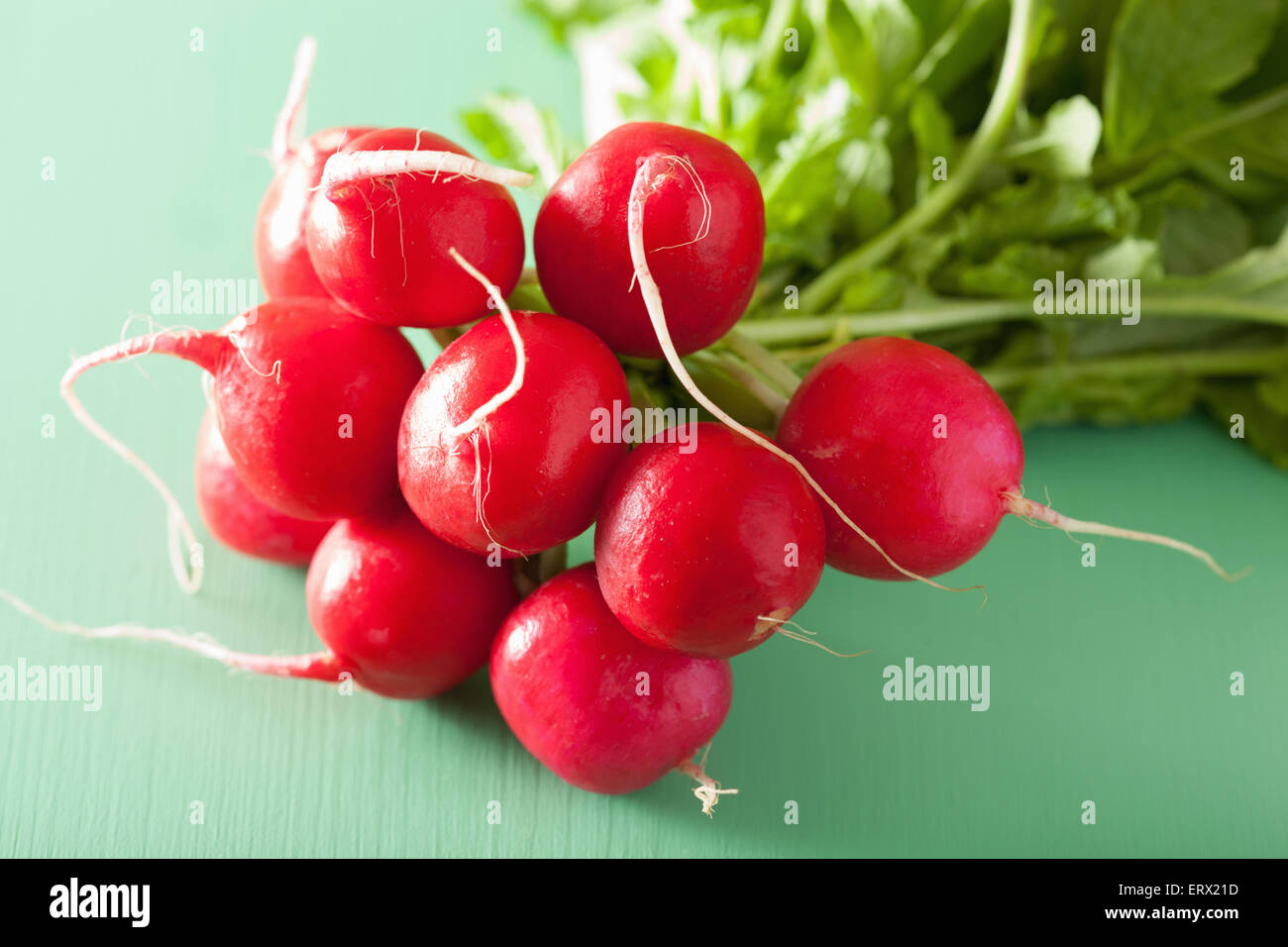 fresh radish with leaves over green background Stock Photo - Alamy