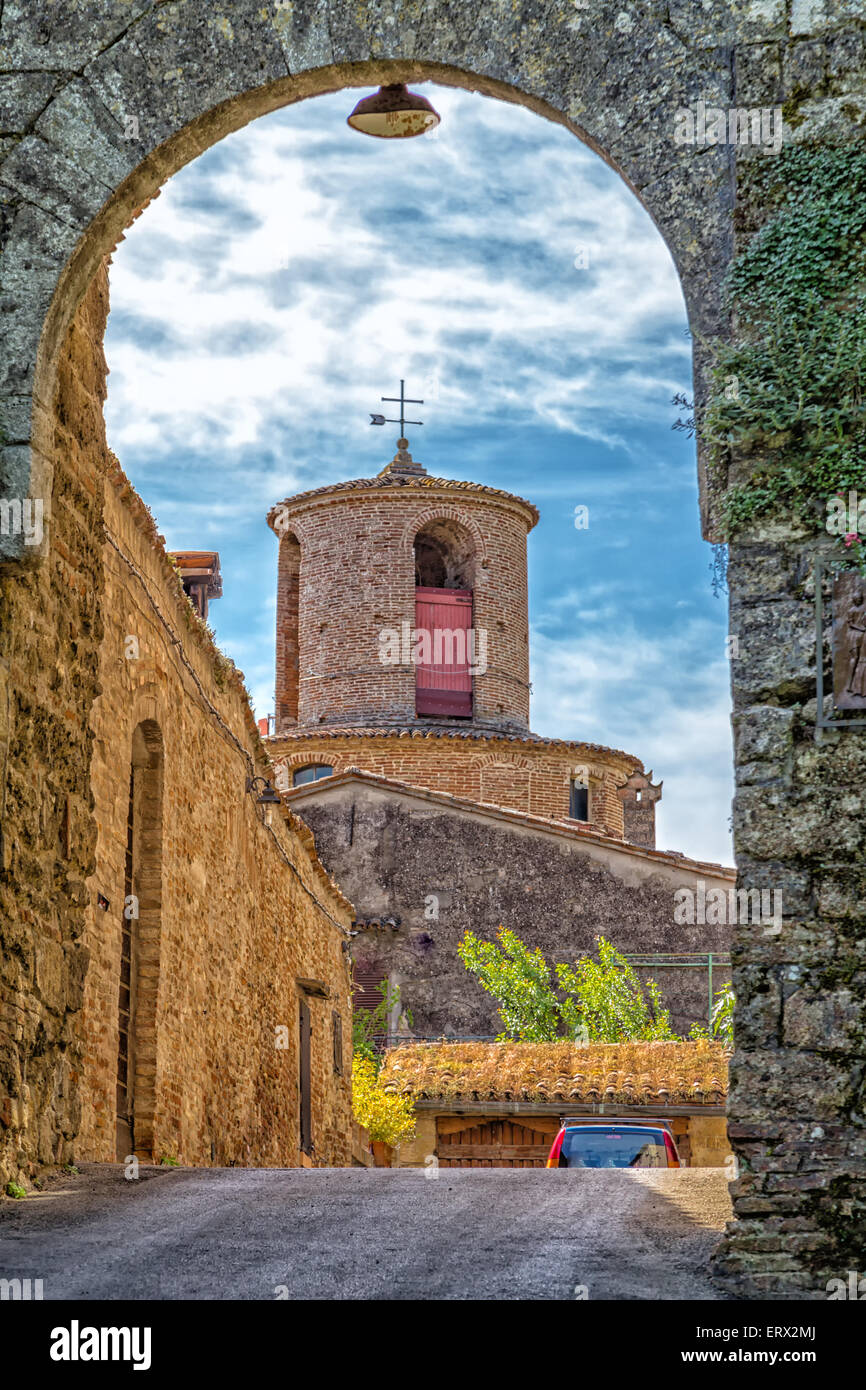 View through an ancient arch of a clock tower with brick walls guarding ...
