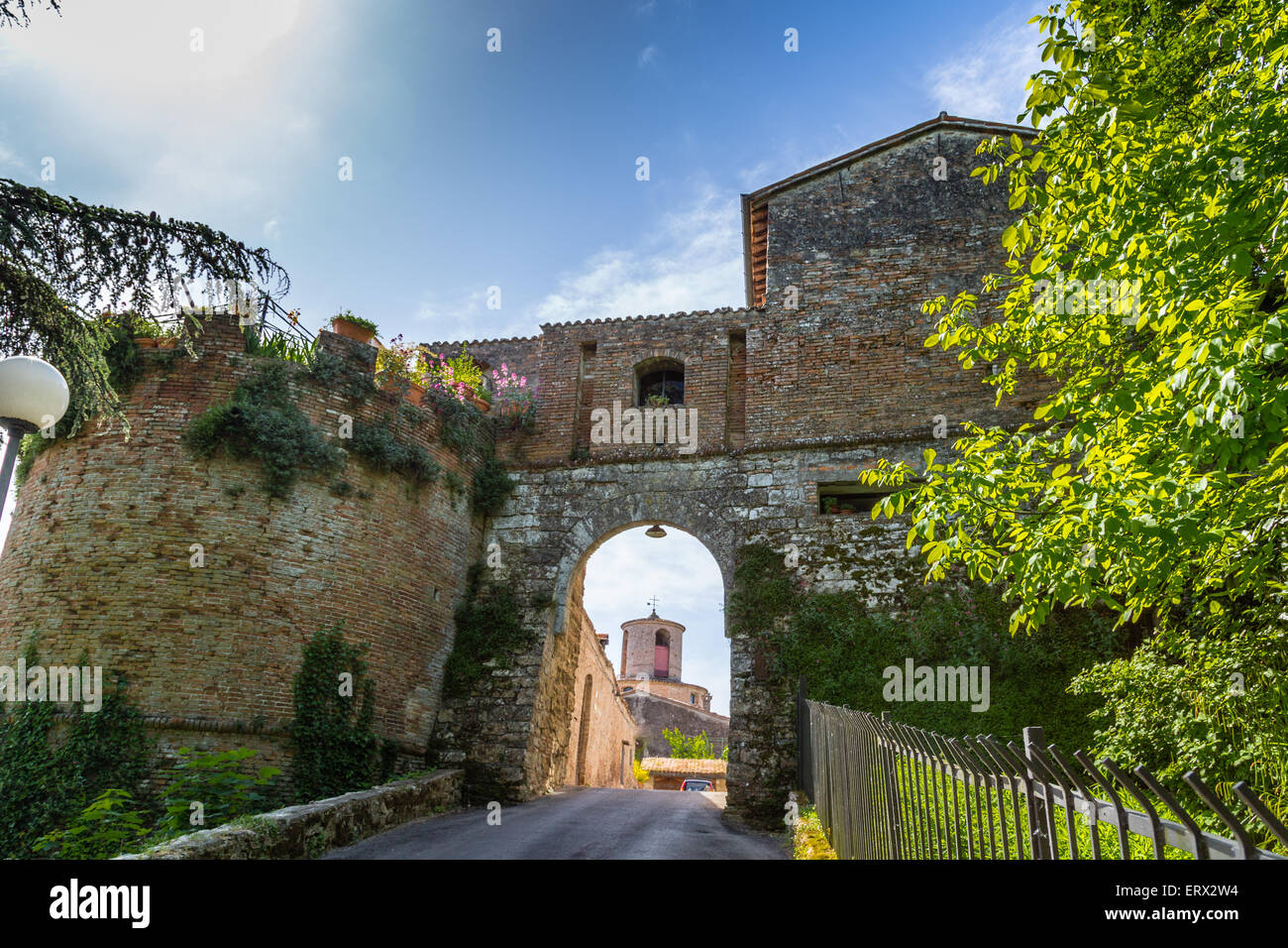 View through an ancient arch of a clock tower with brick walls guarding ...
