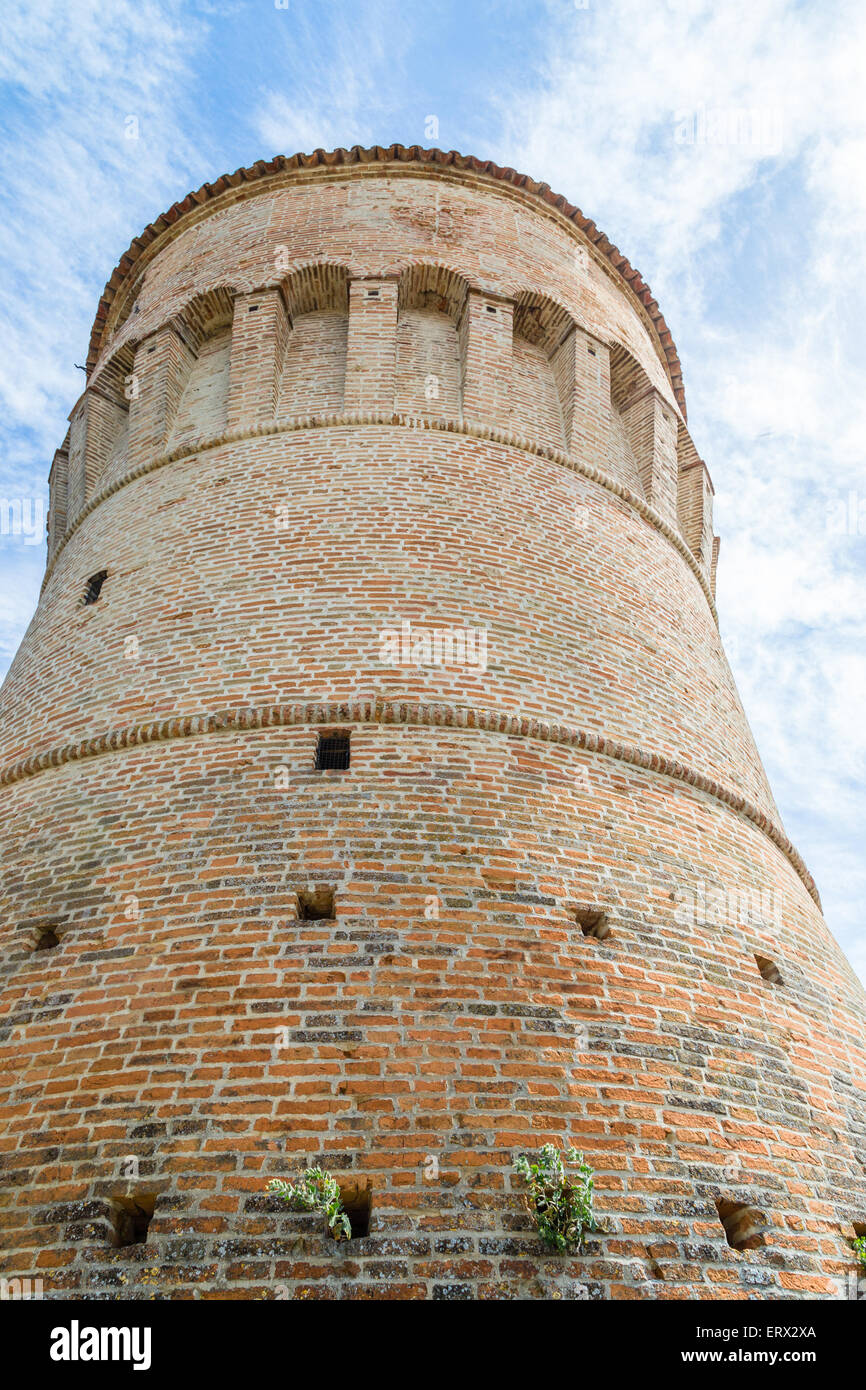 Clock tower with brick walls guarding a countryside village in Italy ...