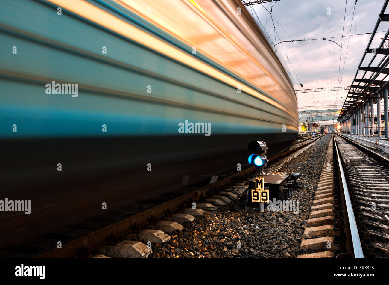 High speed passenger train on tracks with motion blur effect at sunset ...