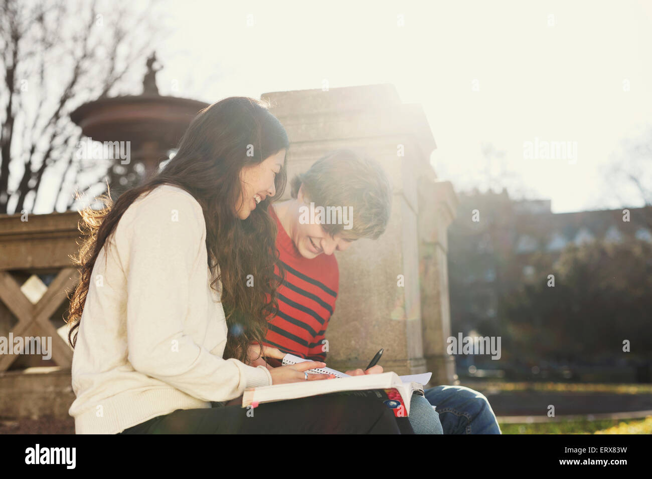 Smiling college students reading book in campus Stock Photo - Alamy