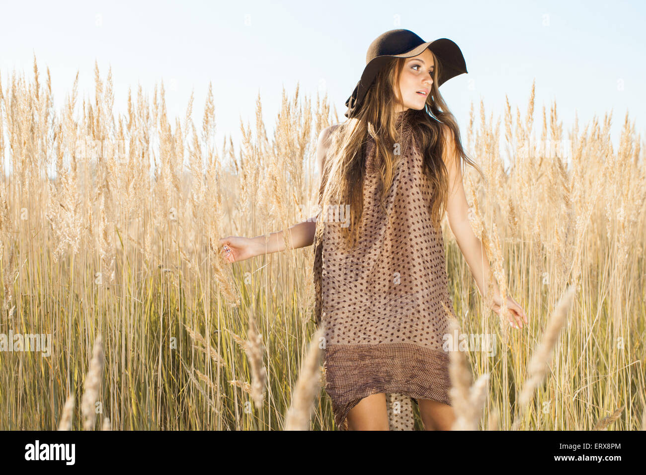 Beautiful young model walking through tallgrass meadow Stock Photo - Alamy