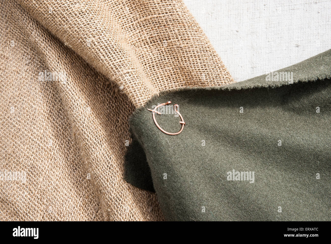 Ancient textile or fabric of three different textures pinned together ...