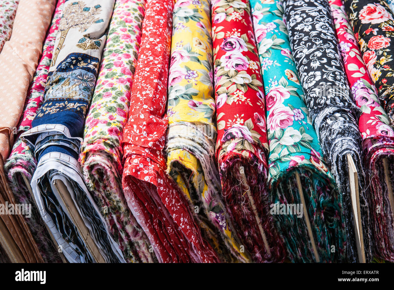 Squares of bright ornamental cloth on display for sale at a local fair ...