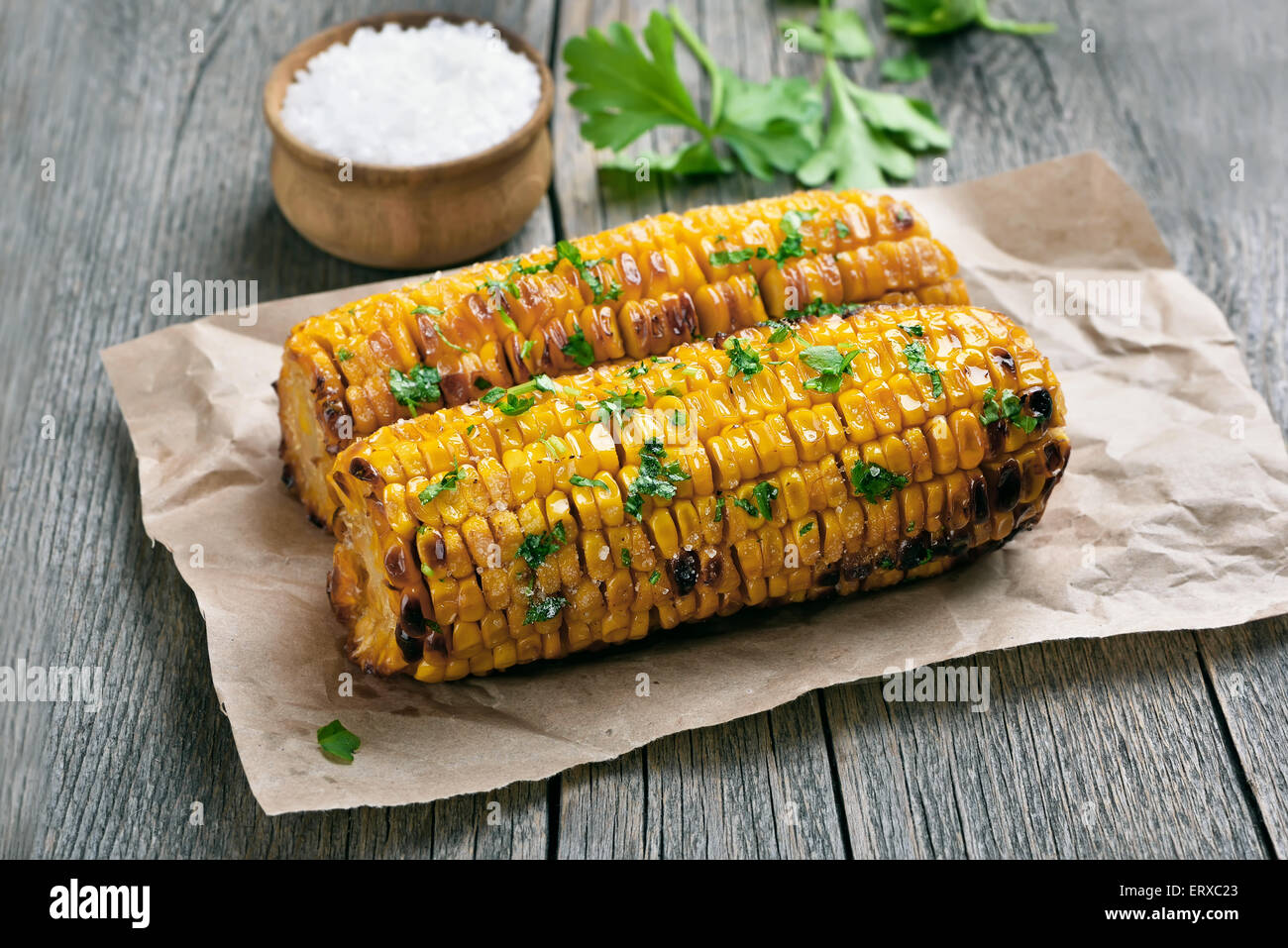 Grilled corn cobs on paper over rustic table Stock Photo - Alamy