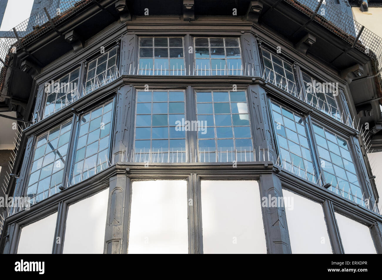 Tudor style timbered building with leaded windows and rows of spikes in ...