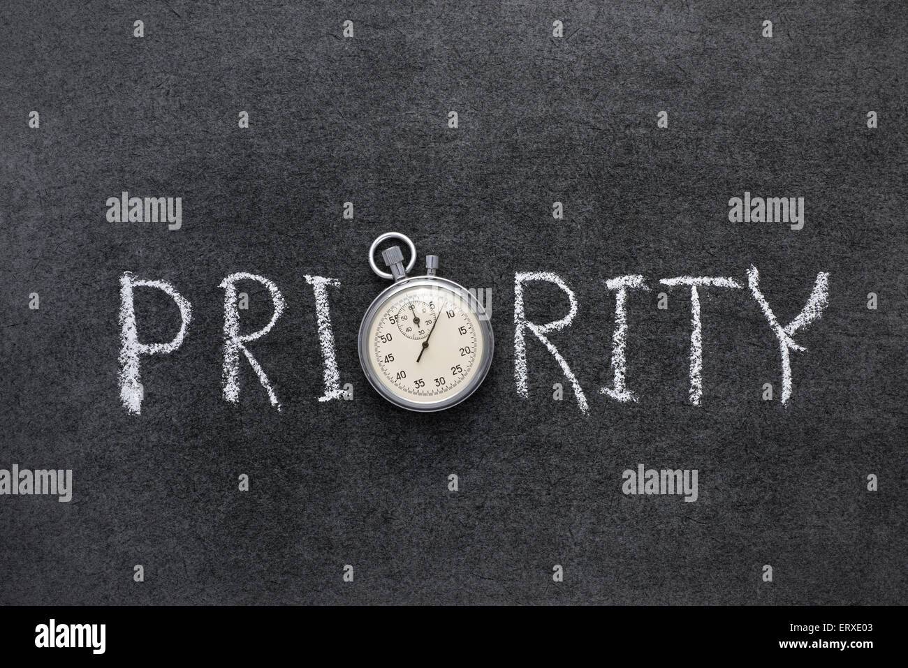 priority word handwritten on chalkboard with vintage precise stopwatch ...