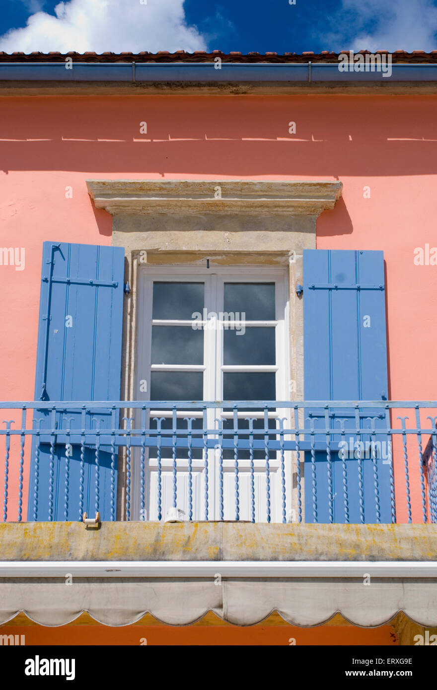 Pastel painted buildings with French style blue shutter windows and ...