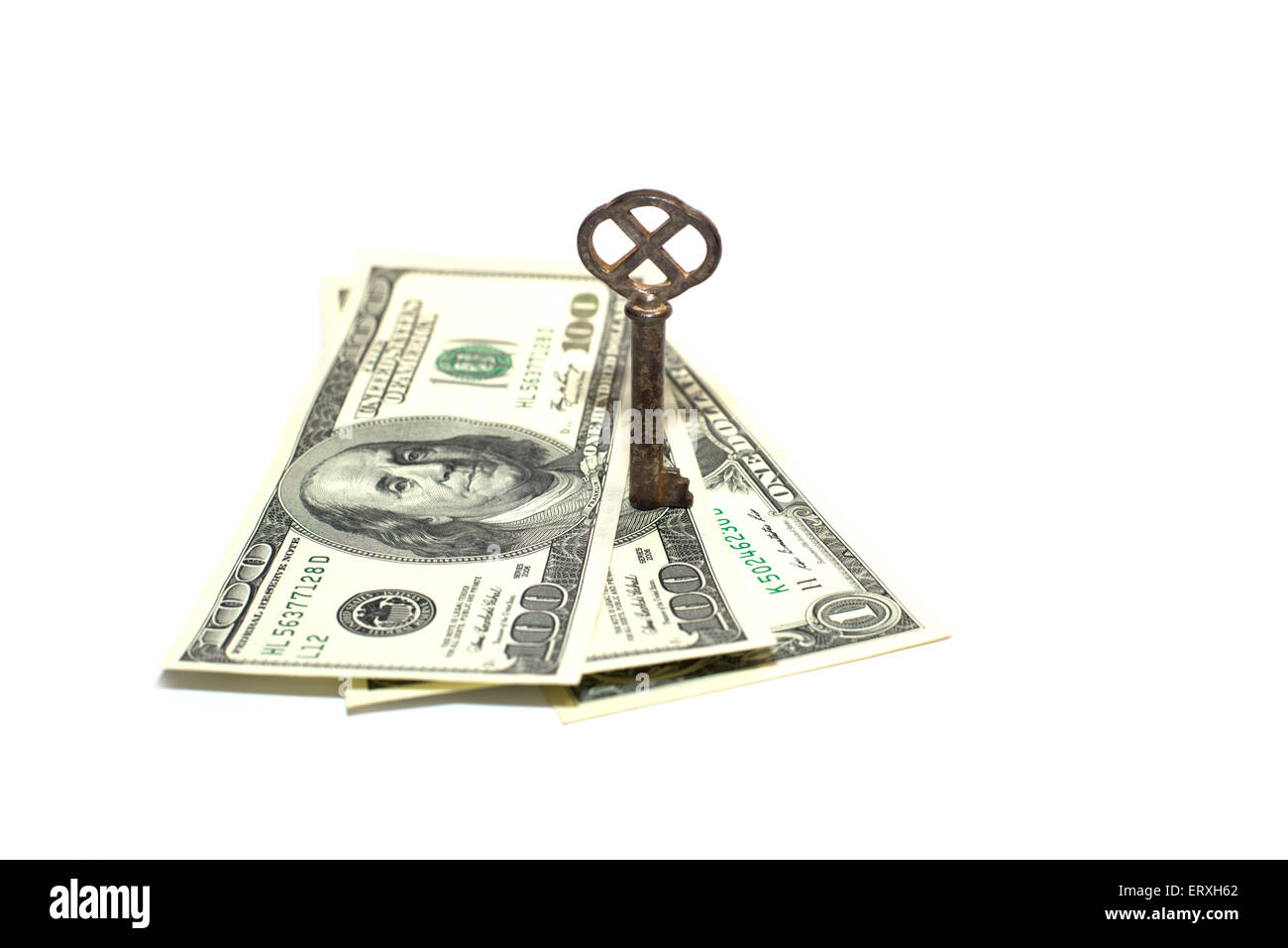 Old key from the door and a few US dollars banknotes on a white ...