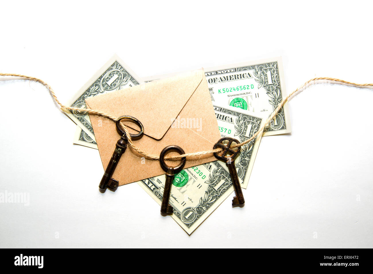 Three old keys, Us dollars banknotes and envelope on a white background ...