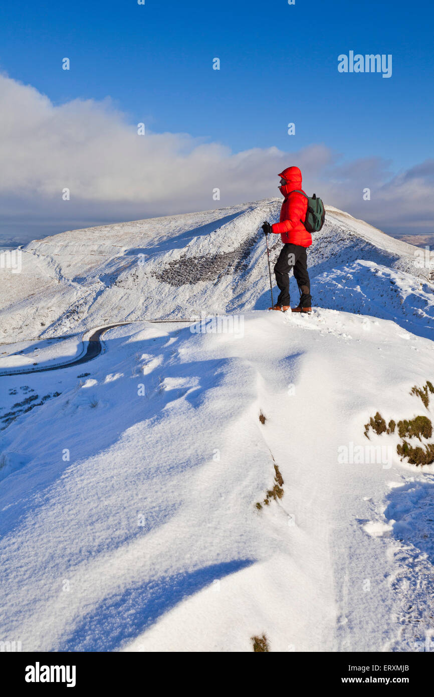 Man Hiking on snow covered peaks Rushup Edge and Mam Tor above ...