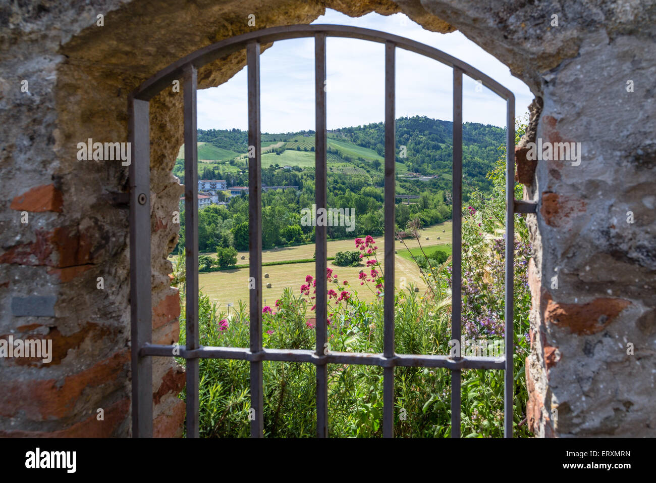 Medieval window with iron grating overlooking the countryside of ...