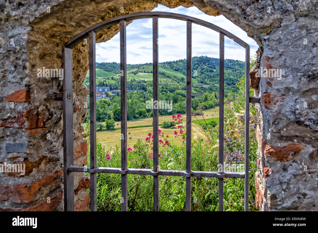 Medieval window with iron grating overlooking the countryside of ...