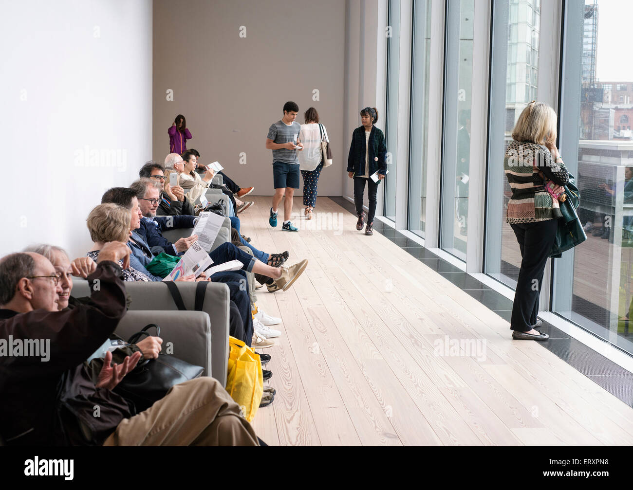 People in the seating area looking over museum guides and taking in the ...