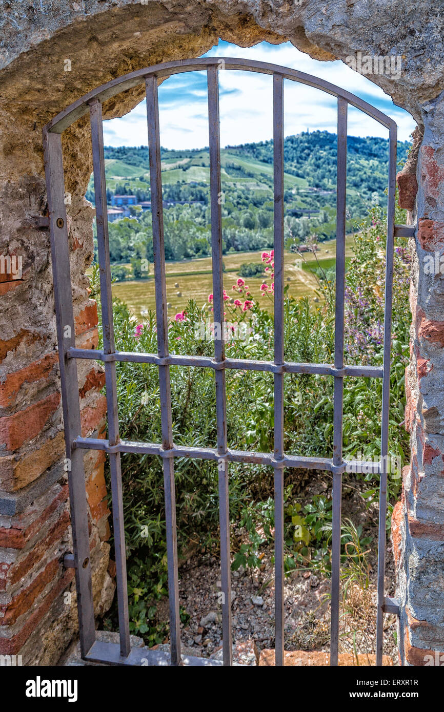 Medieval window with iron grating overlooking the countryside of ...
