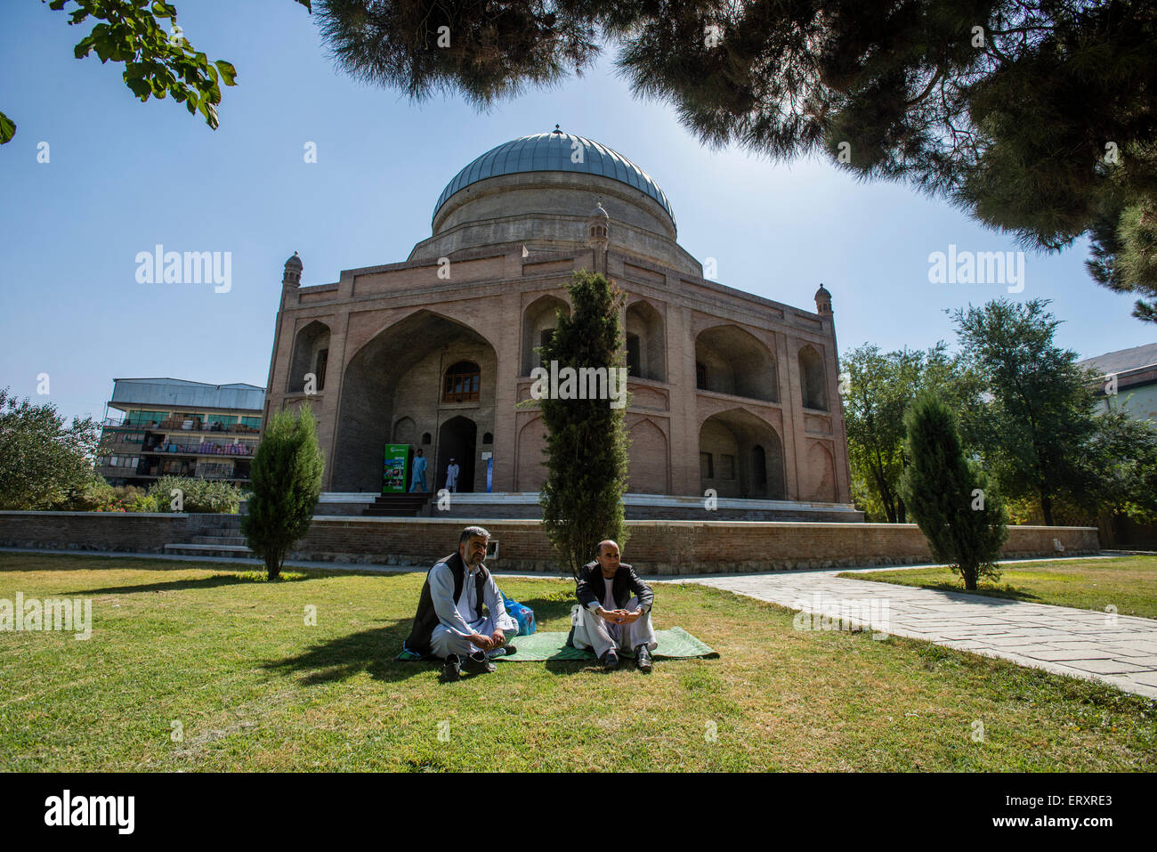Men in Afghan traditional clothes rest in park near Timur Shah ...
