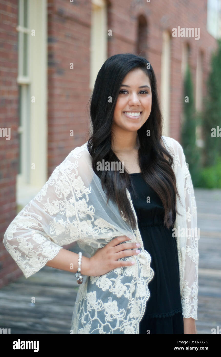 Beautiful and happy senior graduate standing in front of building ...