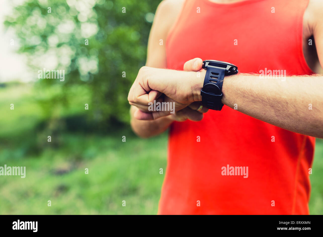 Runner on mountain forest trail looking at sportwatch smart watch ...