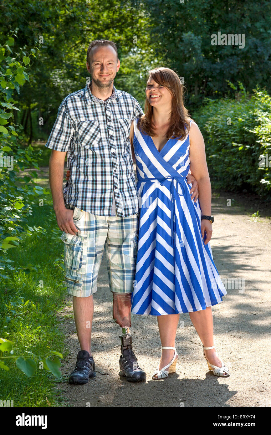 Handsome disabled man wearing an artificial leg standing arm in arm ...