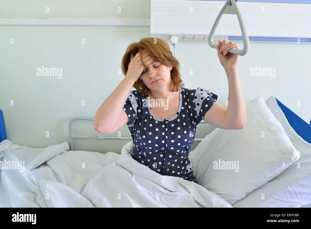 Female patient with headache on a bed in hospital ward Stock Photo - Alamy