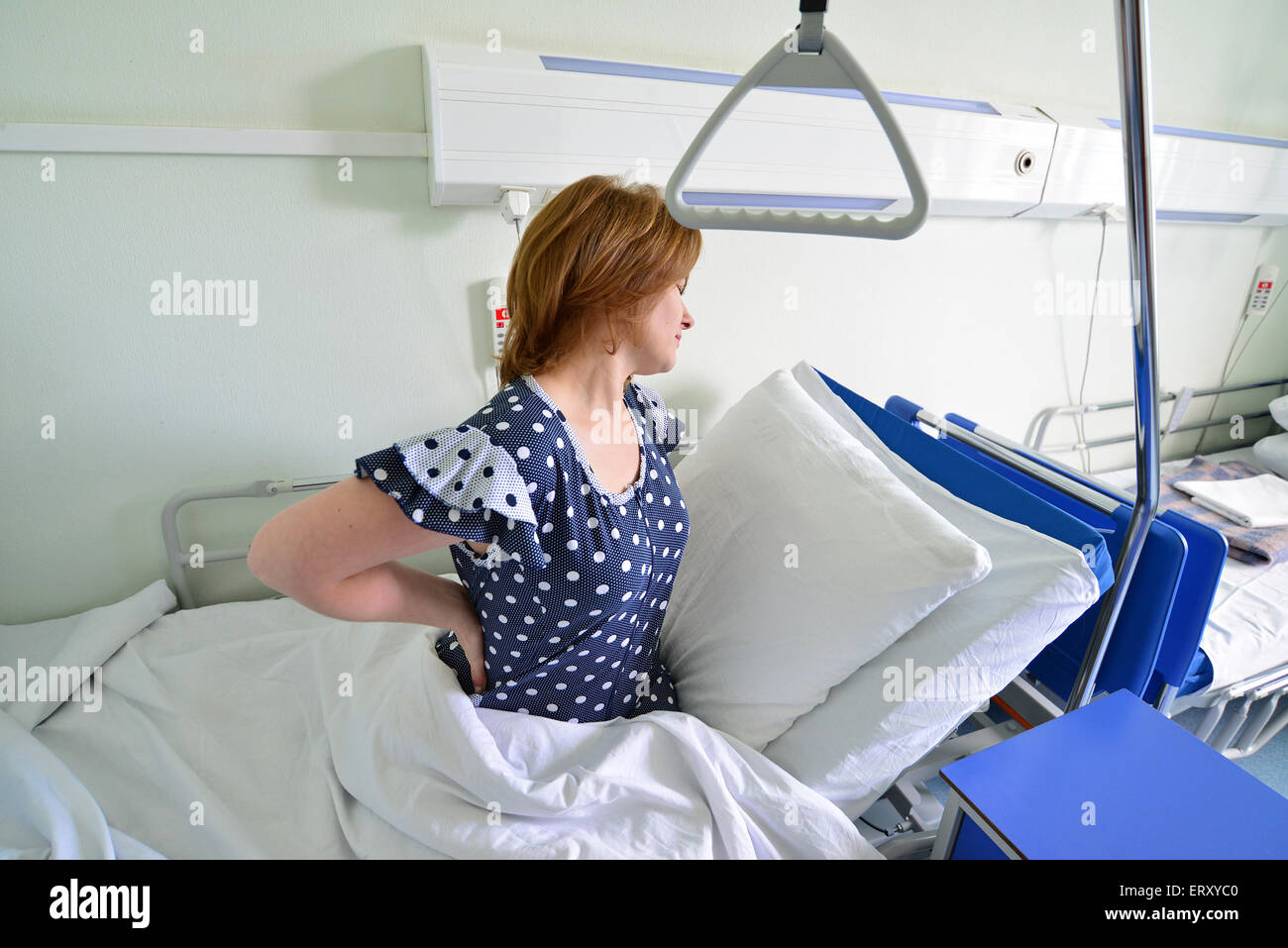 Female patient with back pain on a bed in hospital ward Stock Photo - Alamy