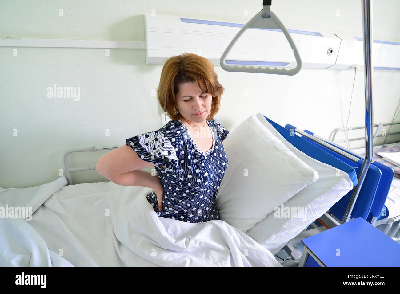 Female patient with back pain on a bed in hospital ward Stock Photo - Alamy