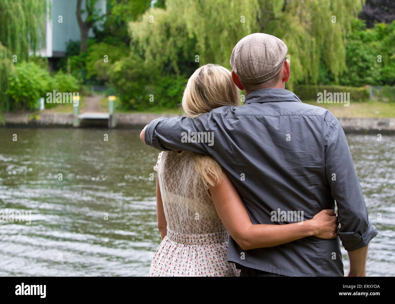 backside of a couple in a park standing by the water Stock Photo - Alamy