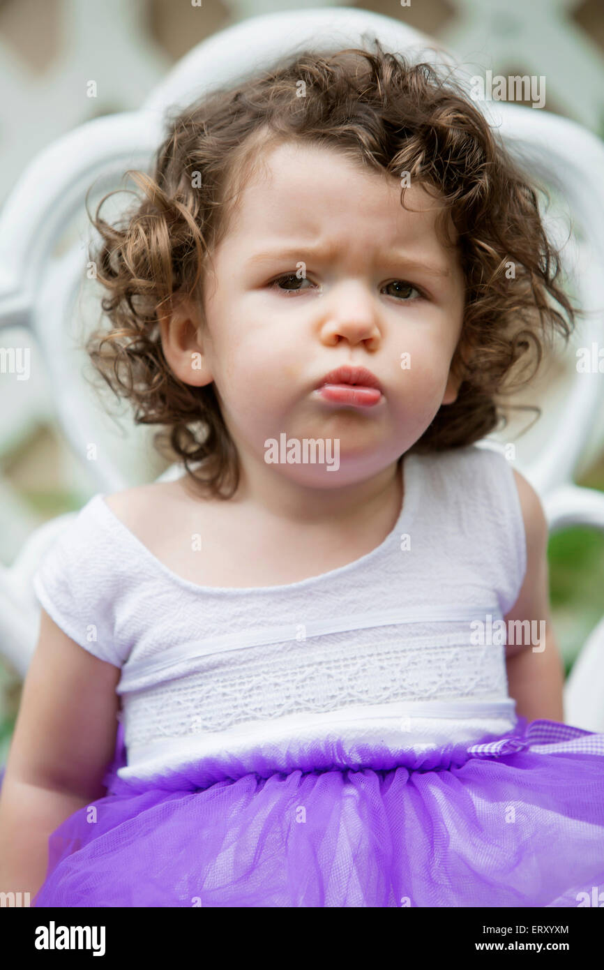 little girl sitting on chair and is pouting Stock Photo - Alamy