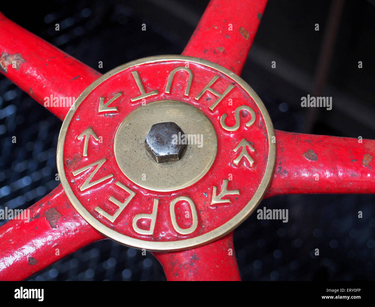 Open and shut - a bright red main control valve wheel on a large static ...