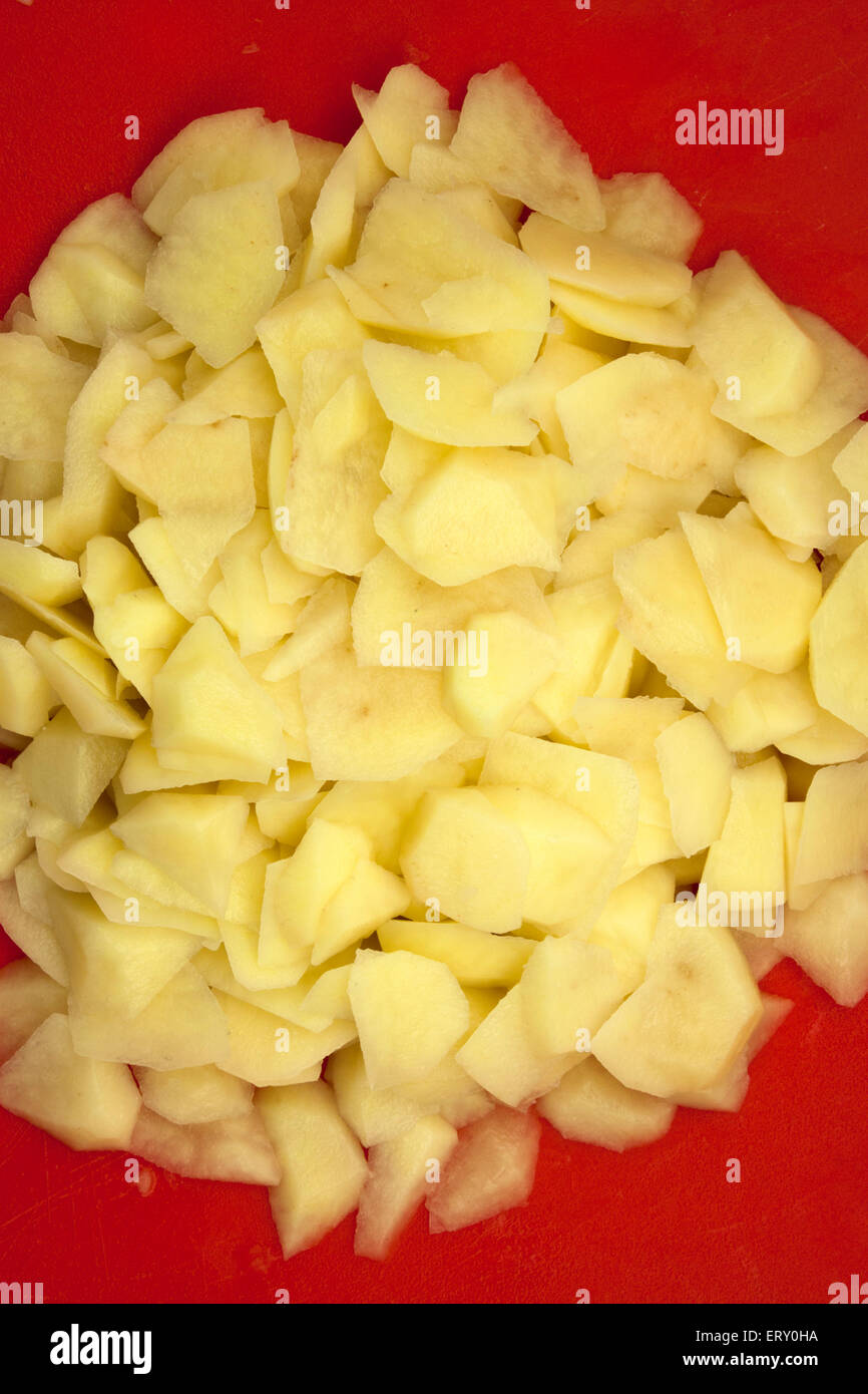 a bunch of chopped potatoes over a red table Stock Photo - Alamy