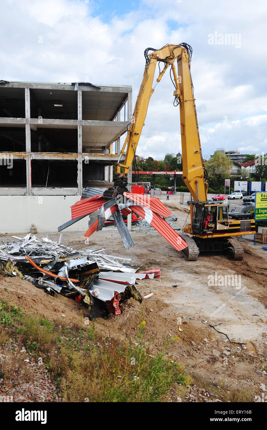 Demolition of a house with yellow construction machine Stock Photo - Alamy