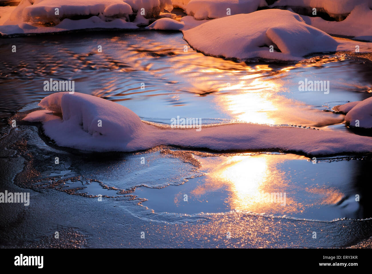 Snow snake figure in the middle of the frozen river after winter sunset ...